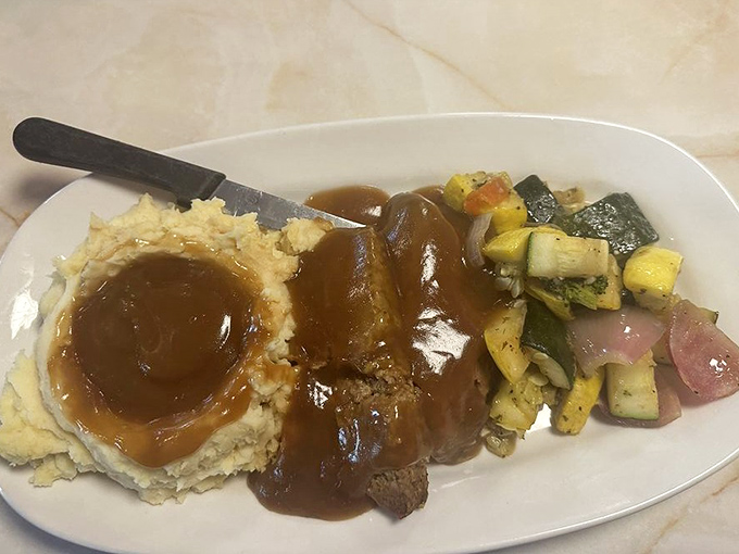 Mama's meatloaf doesn't mess around—tender, savory, and smothered in gravy that would make your grandmother nod in approval.