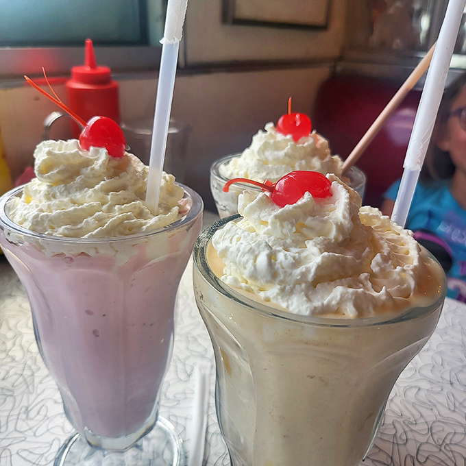 Milkshake masterpieces crowned with whipped cream mountains and cherry beacons—these aren't just desserts, they're dairy-based works of art worth the brain freeze.