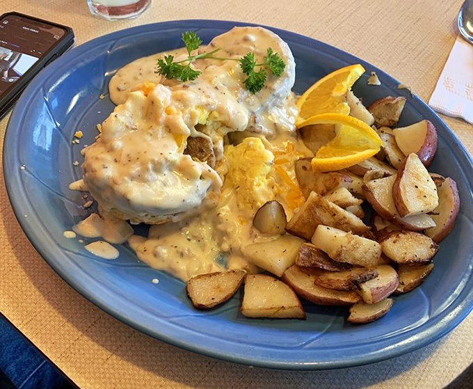 Behold the Mountain Man breakfast—where gravy cascades over biscuits like a savory waterfall, with potatoes standing by for backup.