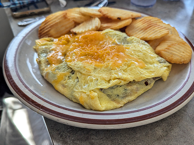 Golden cheese melts into perfectly folded eggs alongside ridged potato chips—proof that sometimes the simplest breakfasts are the most satisfying.