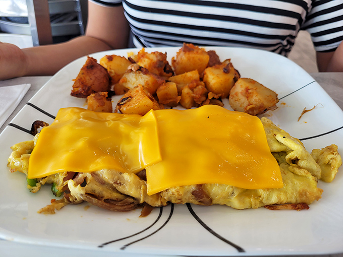 That golden cheese blanket isn't just melted perfection—it's a sunrise on your plate. Those home fries look like they've been practicing their crispy-outside, fluffy-inside routine for decades.