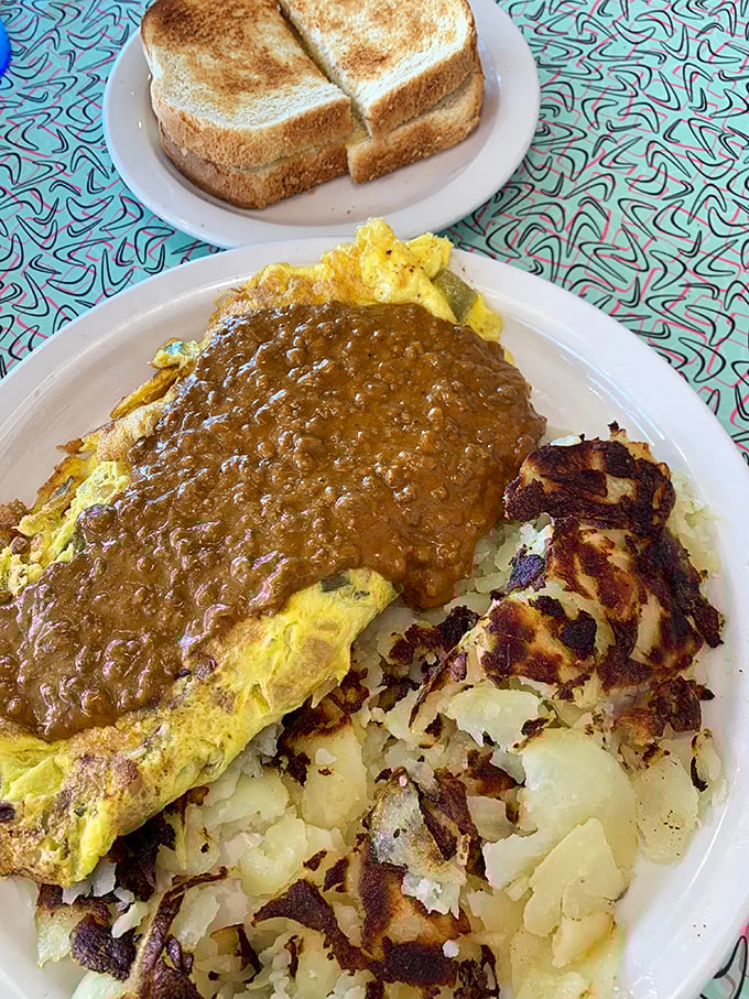 Behold the legendary Southern Omelet in all its glory! Golden eggs blanketed with sausage gravy alongside crispy American fries—a breakfast worth setting your alarm for.