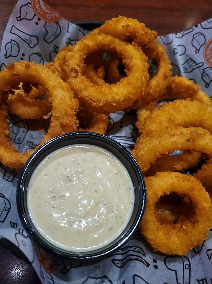 Golden halos of crispy perfection surround tender onion centers. These rings aren't just sides—they're the main event with a supporting cast of dipping sauce.