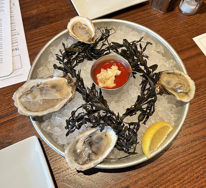 These glistening oysters aren't just seafood—they're time machines to the coast. Served on ice with seaweed and cocktail sauce for a proper oceanic experience.