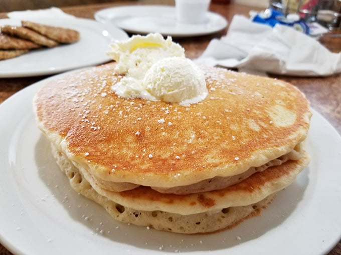 These pancakes don't just sit on the plate—they command it. Golden, fluffy discs topped with butter that melts into every warm, carb-laden pore.
