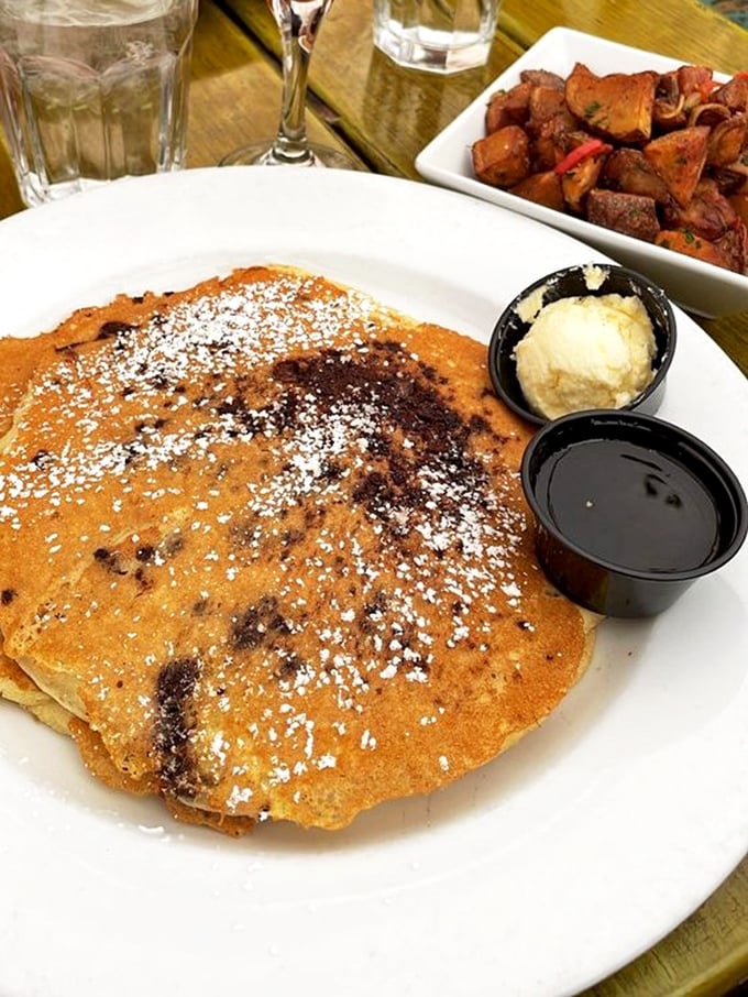 Golden pancakes dusted with powdered sugar, a scoop of butter melting slowly, and maple syrup standing by. Breakfast doesn't get more photogenic.