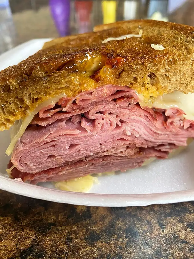 This isn't just a sandwich; it's a pastrami skyscraper with layers of pink perfection that would make a New York deli nod in respectful approval.
