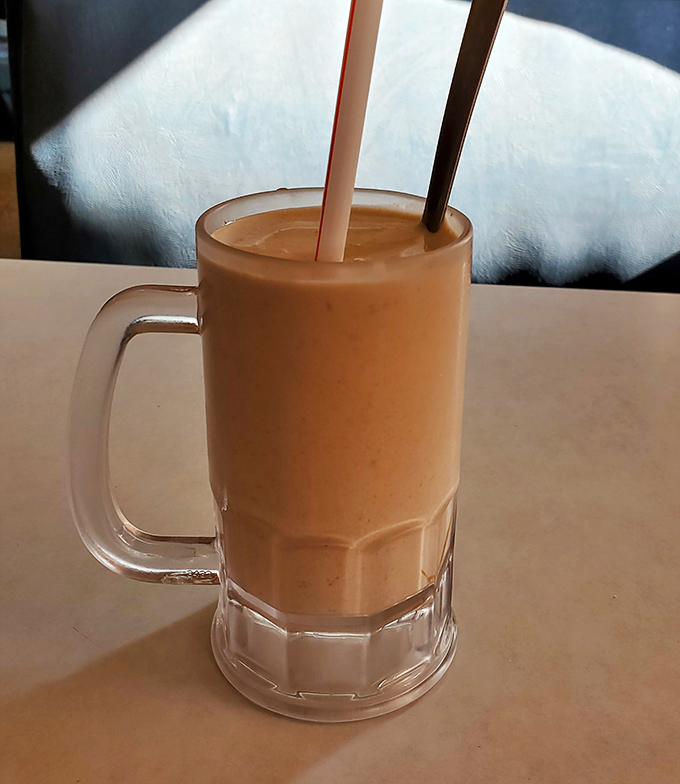 The peanut butter shake arrives like a creamy work of art—thick enough to require serious straw commitment but worth every bit of the effort.