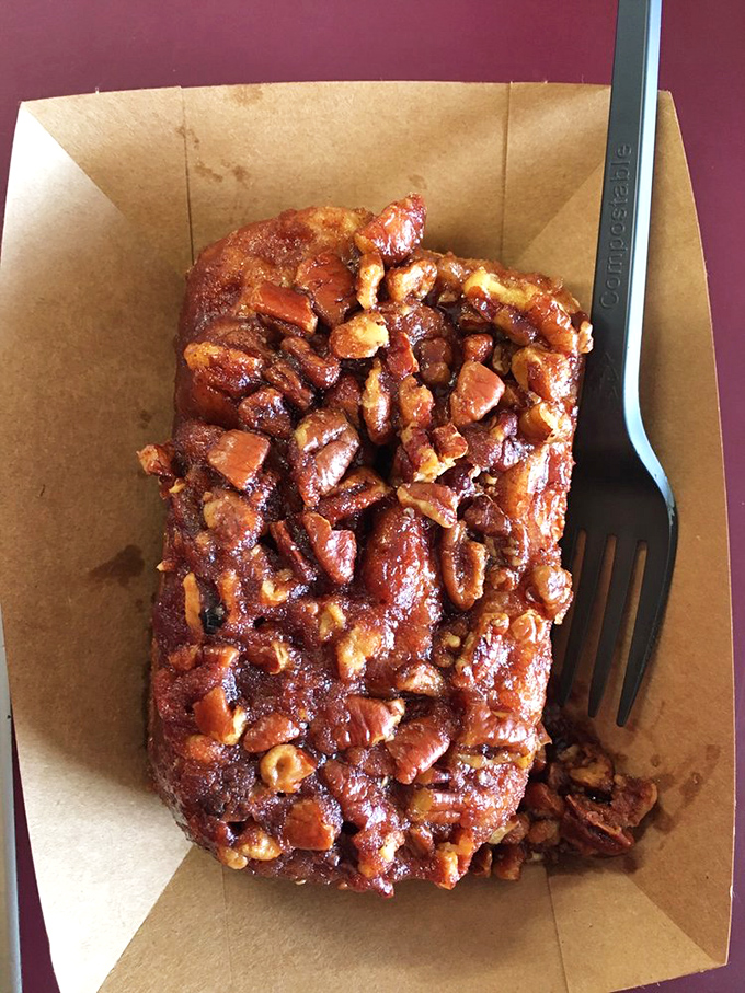 Pecan paradise on a plate. This isn't just a cinnamon roll topped with pecans—it's what breakfast dreams about when breakfast goes to sleep.