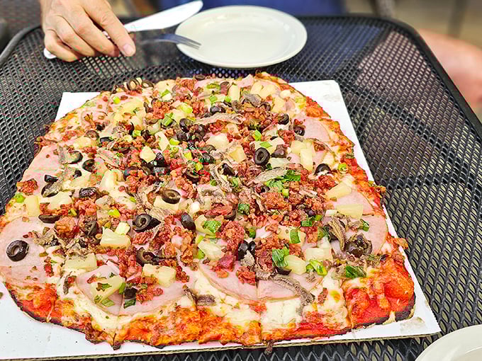 Pizza perfection doesn't need fancy toppings – just look at this loaded pie with its crispy-edge crust and that harmonious balance of meat, veggies, and melty cheese.