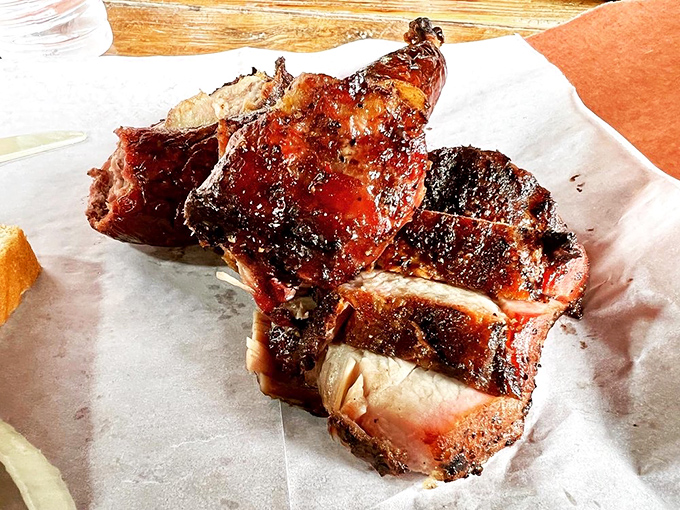 The legendary pork steak—a glistening monument to what happens when smoke, time, and pork shoulder meet under expert supervision. That bark deserves its own art exhibition.