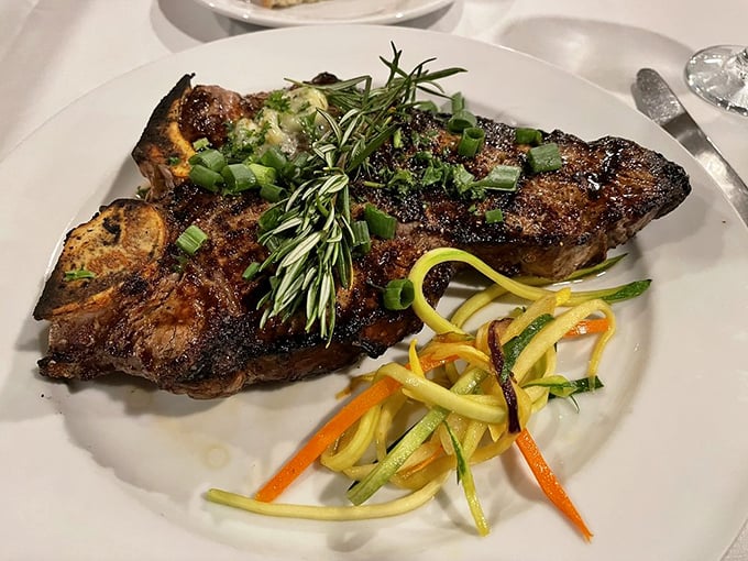 Behold the steak that launched a thousand food dreams. Perfectly charred exterior, rosemary garnish, and those julienned vegetables aren't just sides—they're supporting actors in a meaty masterpiece.