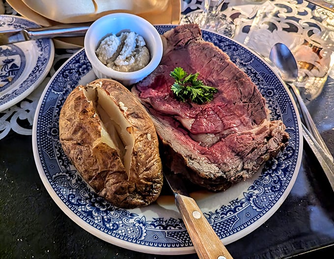 The prime rib arrives like royalty on blue willow china – a perfectly pink centerpiece with a baked potato sidekick that deserves its own fan club.
