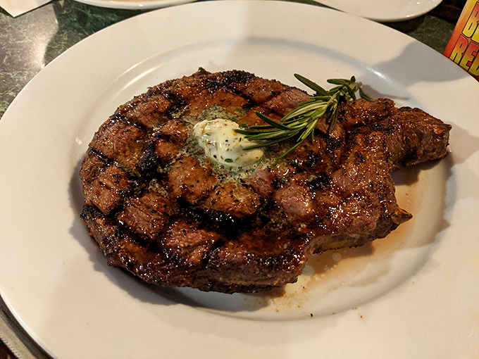 Behold the star of the show—a perfectly grilled steak topped with herb butter that's melting like your resolve to save room for dessert.