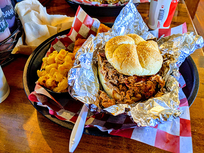 This pulled pork sandwich isn't messing around – tender strands of smoky meat cradled in a soft bun with mac and cheese standing guard.