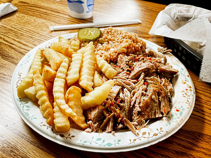 Behold the holy trinity of Southern comfort: pulled pork with that pink smoke ring, golden fries, and that little pickle—nature's palate cleanser.