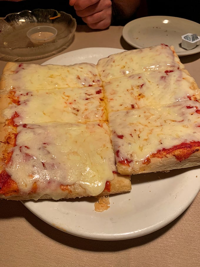 Behold the red pizza in all its glory—those perfect squares of melty cheese and slightly sweet sauce atop that legendary crust.