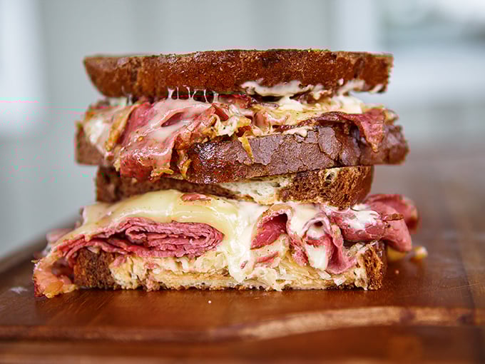 Behold the Reuben in all its glory – layers of corned beef, sauerkraut, and Swiss cheese creating a sandwich architecture that would make Frank Lloyd Wright jealous.