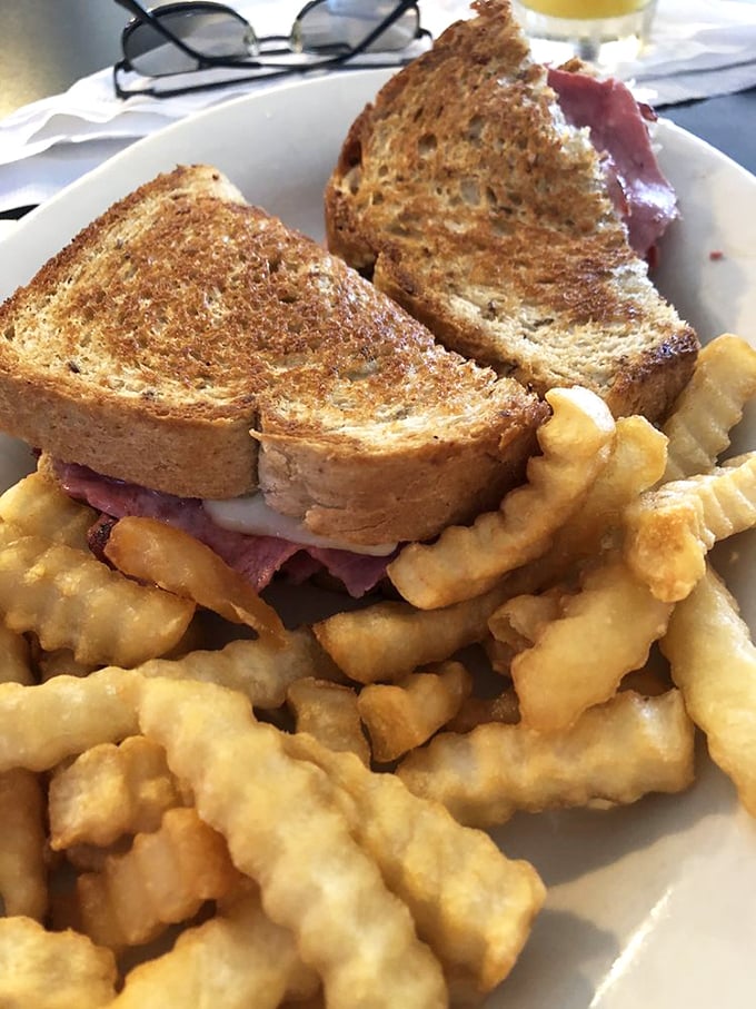 A proper Reuben doesn't need fancy presentation—just perfectly grilled rye, generous corned beef, and those gloriously golden crinkle-cut fries.