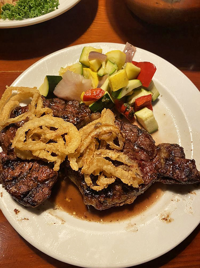 This isn't just a steak—it's a declaration of love to beef. Those crispy onion rings and fresh vegetables provide moral support to the star of the show.