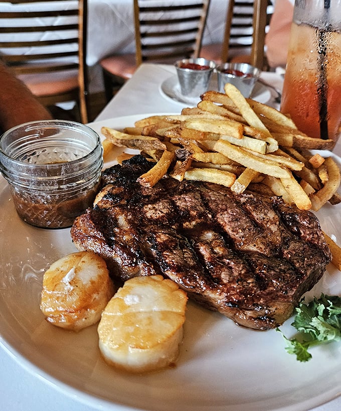 A perfectly seared steak with golden fries and plump scallops—this plate doesn't need Instagram filters, just your undivided attention.