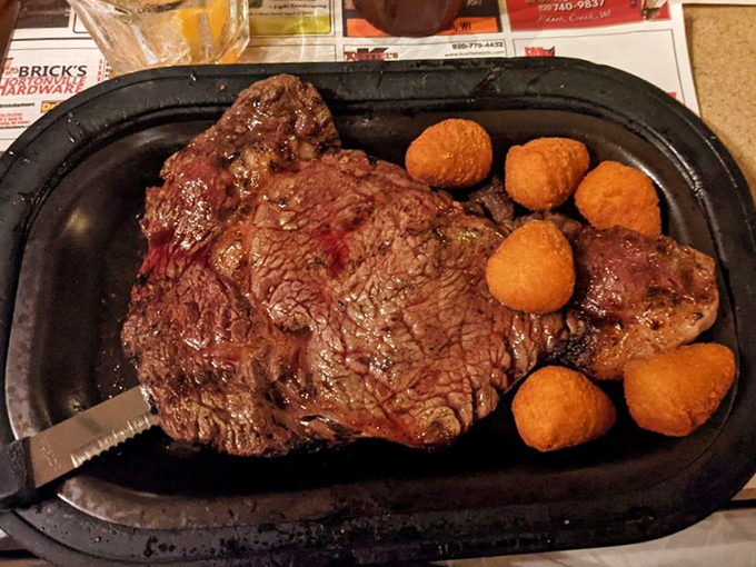 Behold the star of the show—a perfectly seared ribeye accompanied by golden cheese curds. This isn't just dinner; it's a Wisconsin rite of passage.