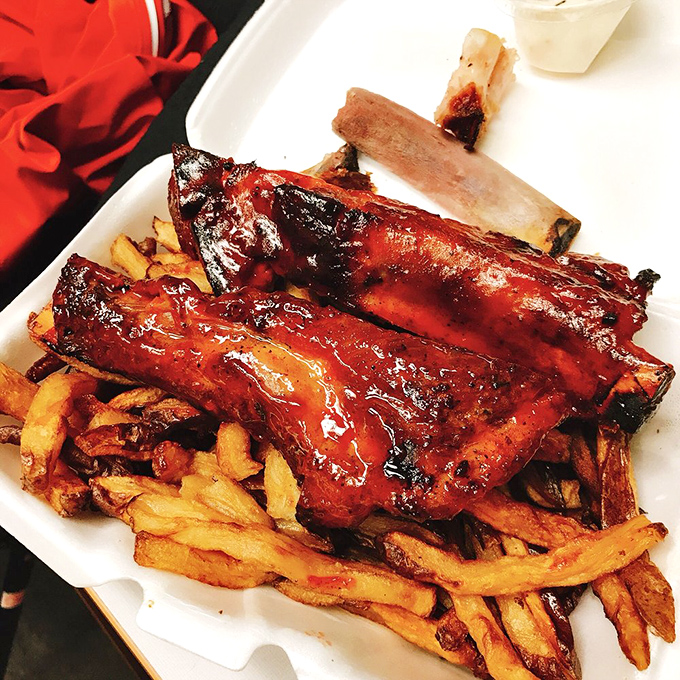 These ribs don't need fancy plating – they're the supermodels of barbecue, glistening with sauce and posing seductively atop a bed of golden fries.