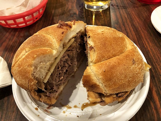 The roast beef sandwich arrives like a meaty revelation on a humble white plate. Split open to reveal its tender soul—this is sandwich architecture at its most honest.