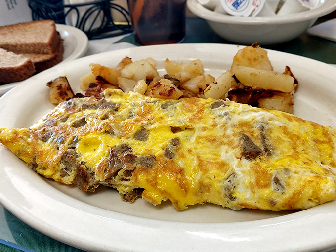This omelet didn't just incorporate cheese and sausage – it embraced them in a golden-hued love affair that makes morning worth facing.