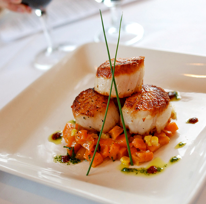 These sea scallops aren't just seared—they're transformed into caramelized perfection, perched like royalty above a vibrant carrot medley that's playing a delicious supporting role.