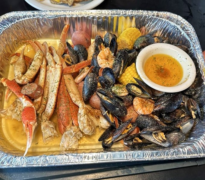 This seafood boil isn't messing around—crab legs, mussels, shrimp, and corn on the cob swimming in buttery broth that practically demands you wear the paper bib of honor.