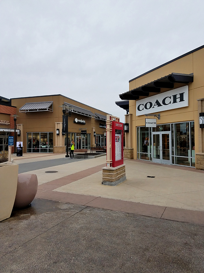 Coach corner beckons with the siren song of luxury at less painful prices. That red phone booth isn't for emergencies—unless running out of shopping bags counts.