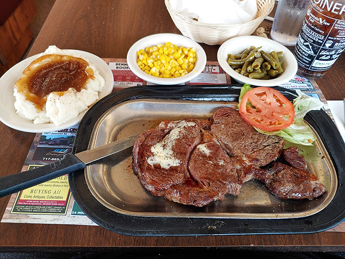 Behold the star of our show! This sirloin arrives sizzling on its metal throne, surrounded by loyal subjects of corn, mashed potatoes, and green beans.