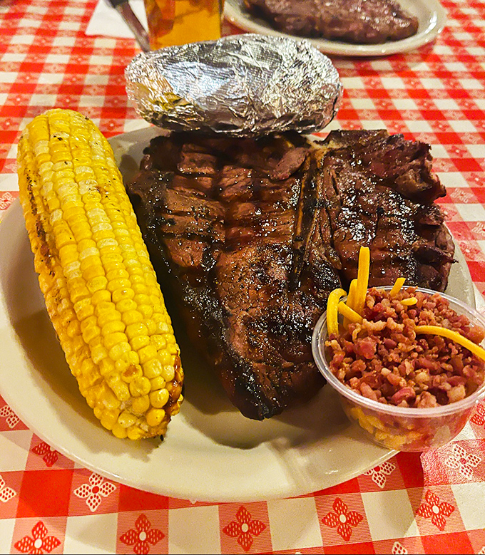 Carnivore heaven on a plate! This T-bone doesn't just hang off the edge—it practically needs its own ZIP code, with corn and beans playing worthy sidekicks.