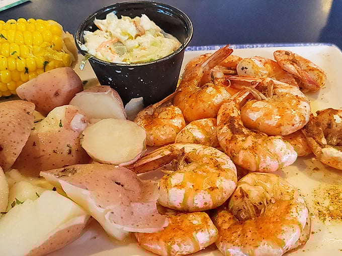 Perfectly seasoned shrimp nestled alongside red potatoes and corn on the cob – a holy trinity of Gulf Coast comfort that speaks to your soul.