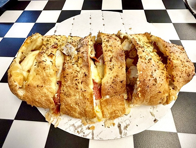 Behold the Stromboli in all its golden-crusted glory—a magnificent package of melted cheese and savory fillings that demands your immediate attention.