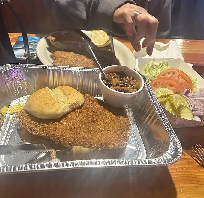Behold the legendary tenderloin—a golden-brown masterpiece that laughs at the concept of fitting on a bun. Worth every delicious calorie.