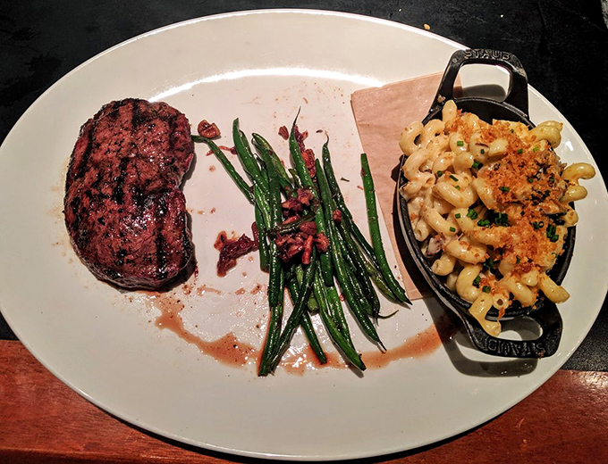 A perfectly seared steak alongside vibrant green beans and mac & cheese that's dressed better than most people at formal events. This plate doesn't need a filter.