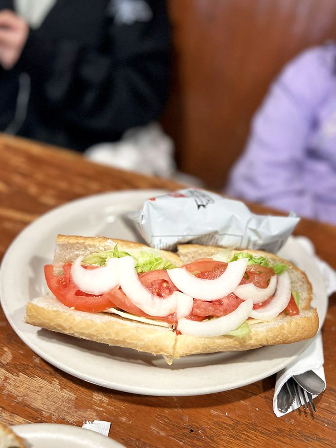 Simple perfection on a plate – fresh tomatoes and crisp onions nestled in bread that knows its purpose is to deliver, not distract.