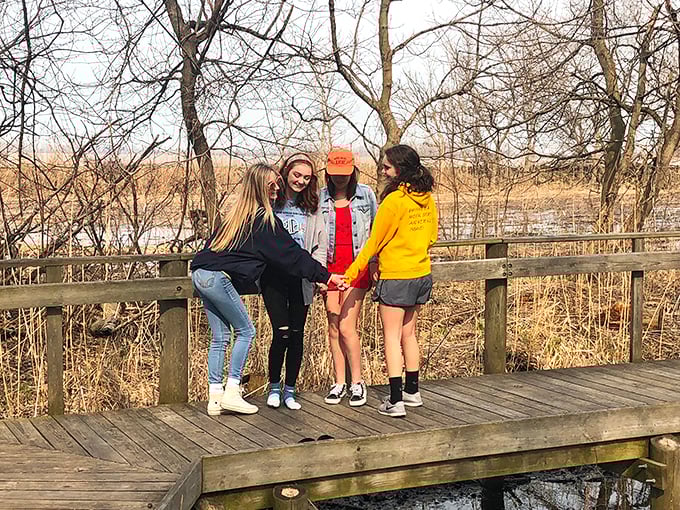 Four friends finding their balance on the boardwalk—proof that nature's playground works better than any team-building exercise corporate America could devise. 
