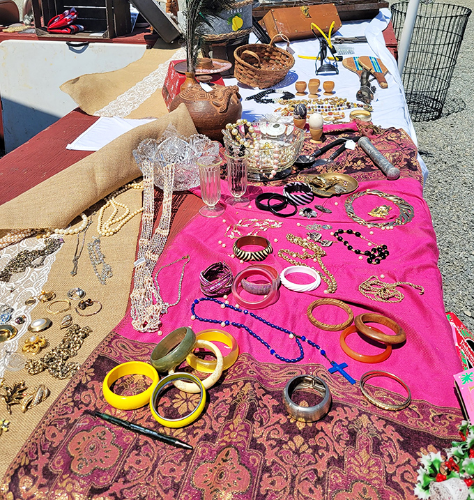Vintage jewelry sparkles on pink fabric like a pirate's treasure chest, offering glamour without requiring a second mortgage payment.