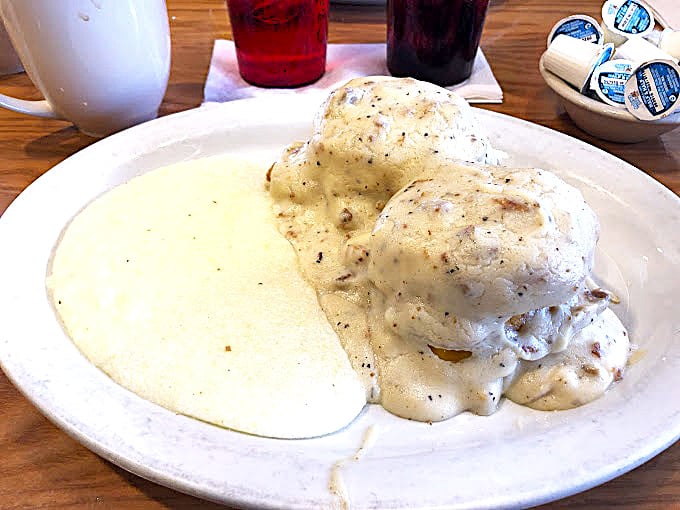 Behold the star attraction: pillowy biscuits drowning in peppery sausage gravy. This isn't just breakfast—it's an edible hug for your soul.