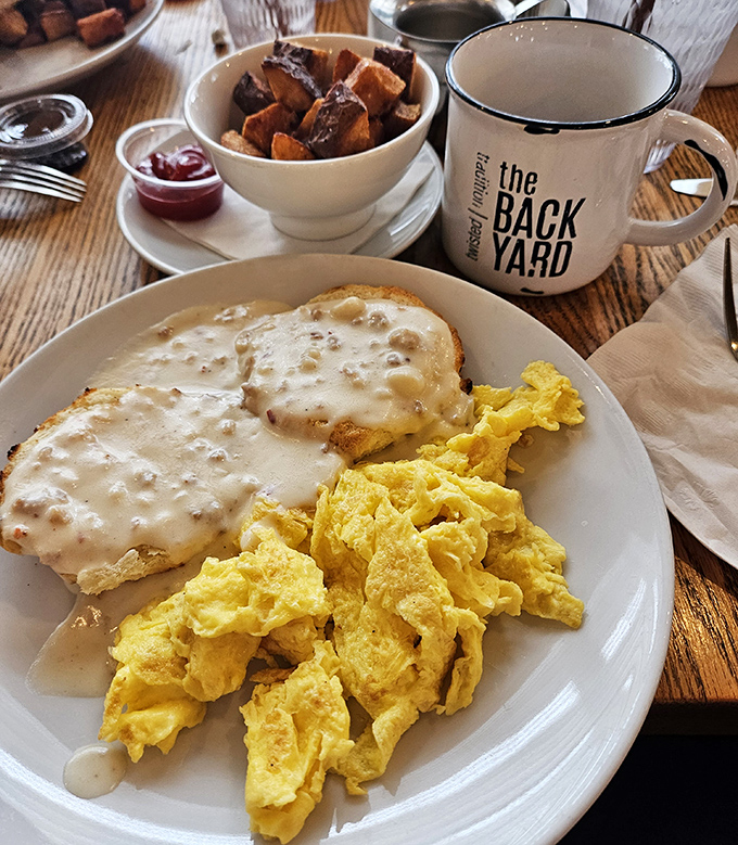 Breakfast nirvana: fluffy scrambled eggs alongside creamy biscuits smothered in savory gravy. That coffee mug isn't just for show—you'll need it.