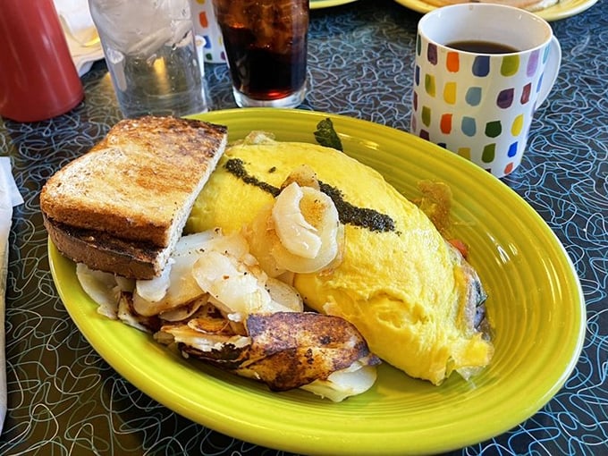 This isn't just an omelet—it's a golden envelope of morning joy, delivering its cheesy contents alongside perfectly crisped potatoes and toast.