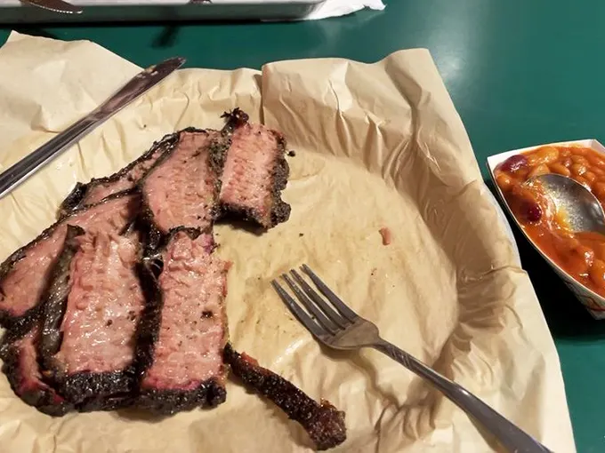 Behold the holy trinity of barbecue perfection: pink smoke ring, mahogany bark, and meat so tender it practically surrenders to your fork.