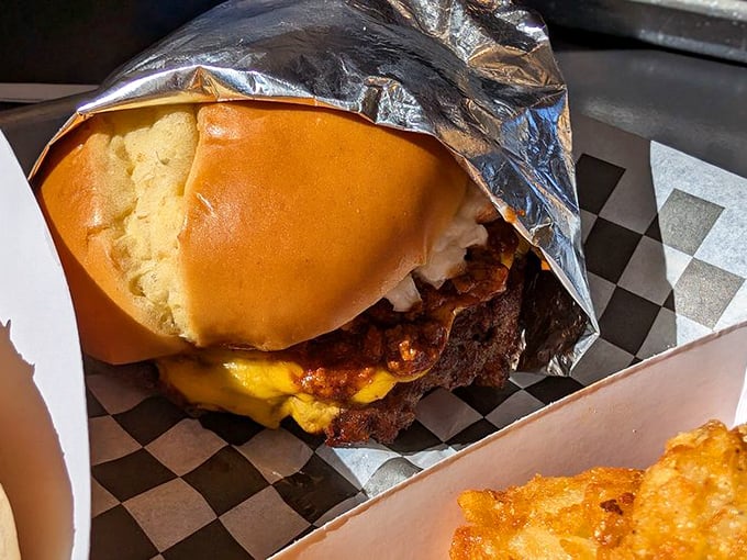 Behold the star of the show—crispy-edged, juicy-centered perfection wrapped in foil. This isn't just a burger; it's edible architecture.