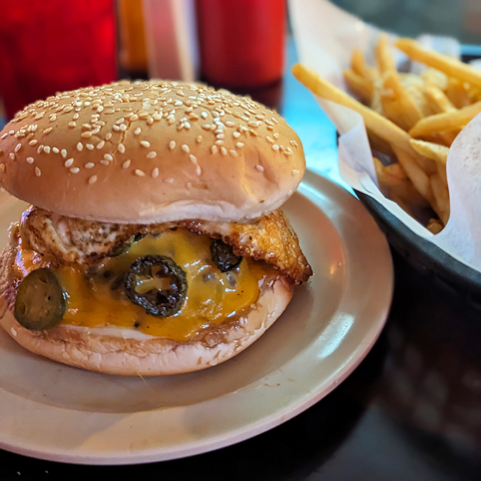 This isn't just a burger—it's edible architecture. Melted cheese cascades over the patty while pickles and jalapeños add a perfect tang.