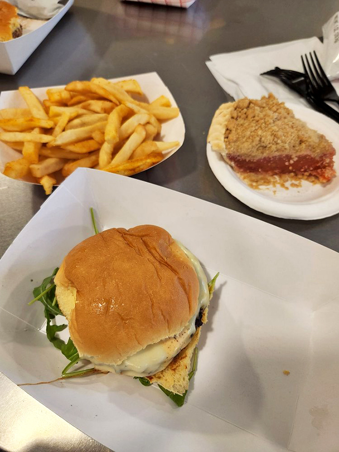 This isn't just a burger—it's a handheld masterpiece with a supporting cast of golden fries and what appears to be pie in the background. Strategic ordering!