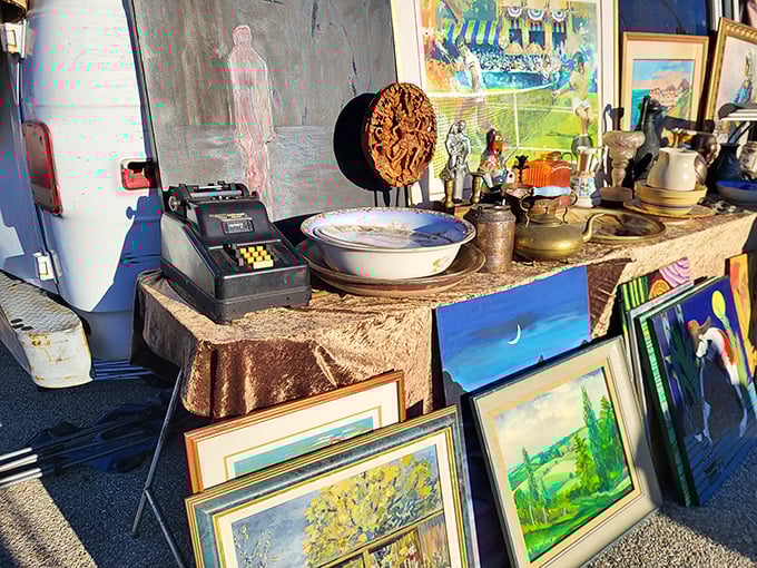 Nostalgia arranged on makeshift tables—vintage cash registers and landscape paintings waiting for their second act in someone's carefully curated home.