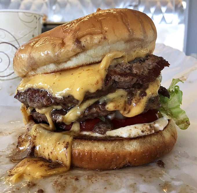 Not so much a burger as a skyscraper of beef and cheese—this masterpiece requires both hands, several napkins, and absolutely no shame.